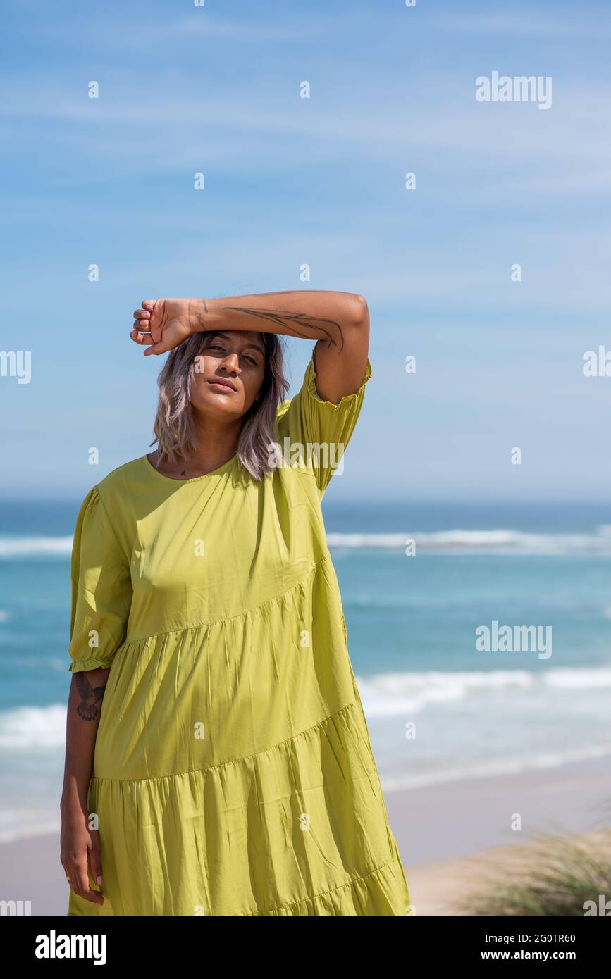 Portrait of woman covering the sun with her arm hi-res stock ...