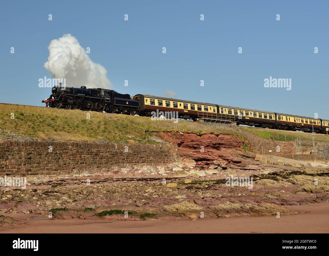 Steam train climbing the gradient past Goodrington beach on the ...
