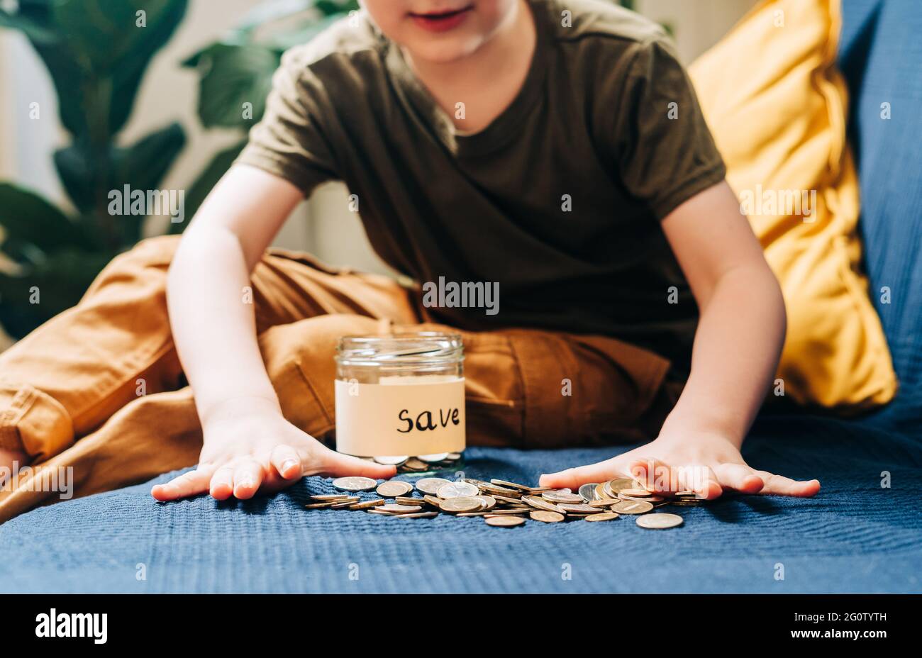 Close up of Little child kid boy hands grabbing and putting stack coins ...