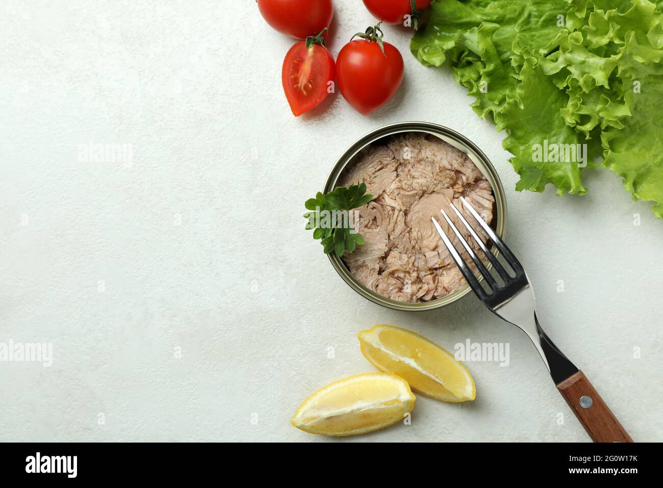 Concept of tasty eating with canned tuna on white textured background ...