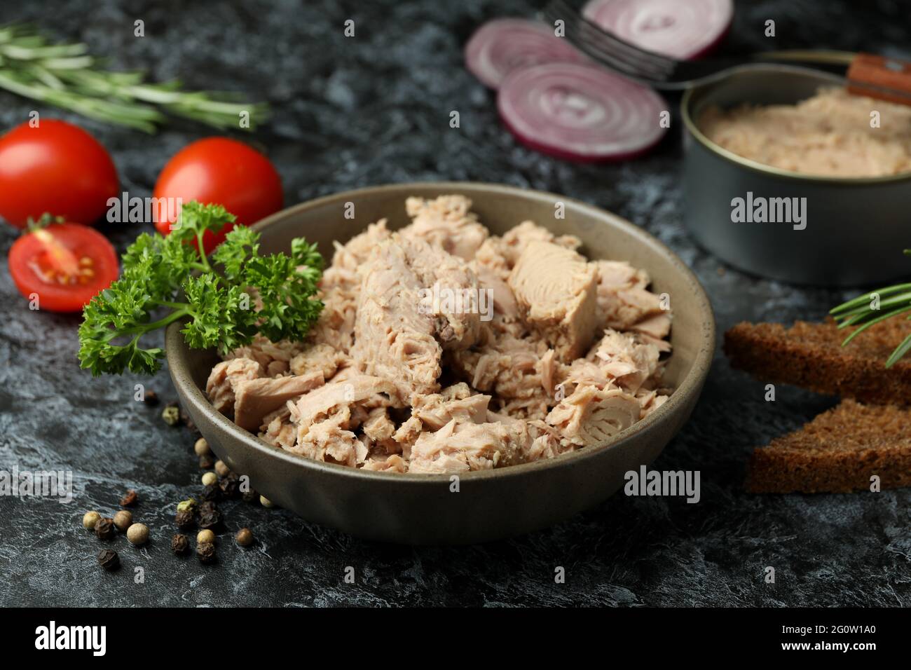 Concept of tasty eating with canned tuna on black smokey background ...