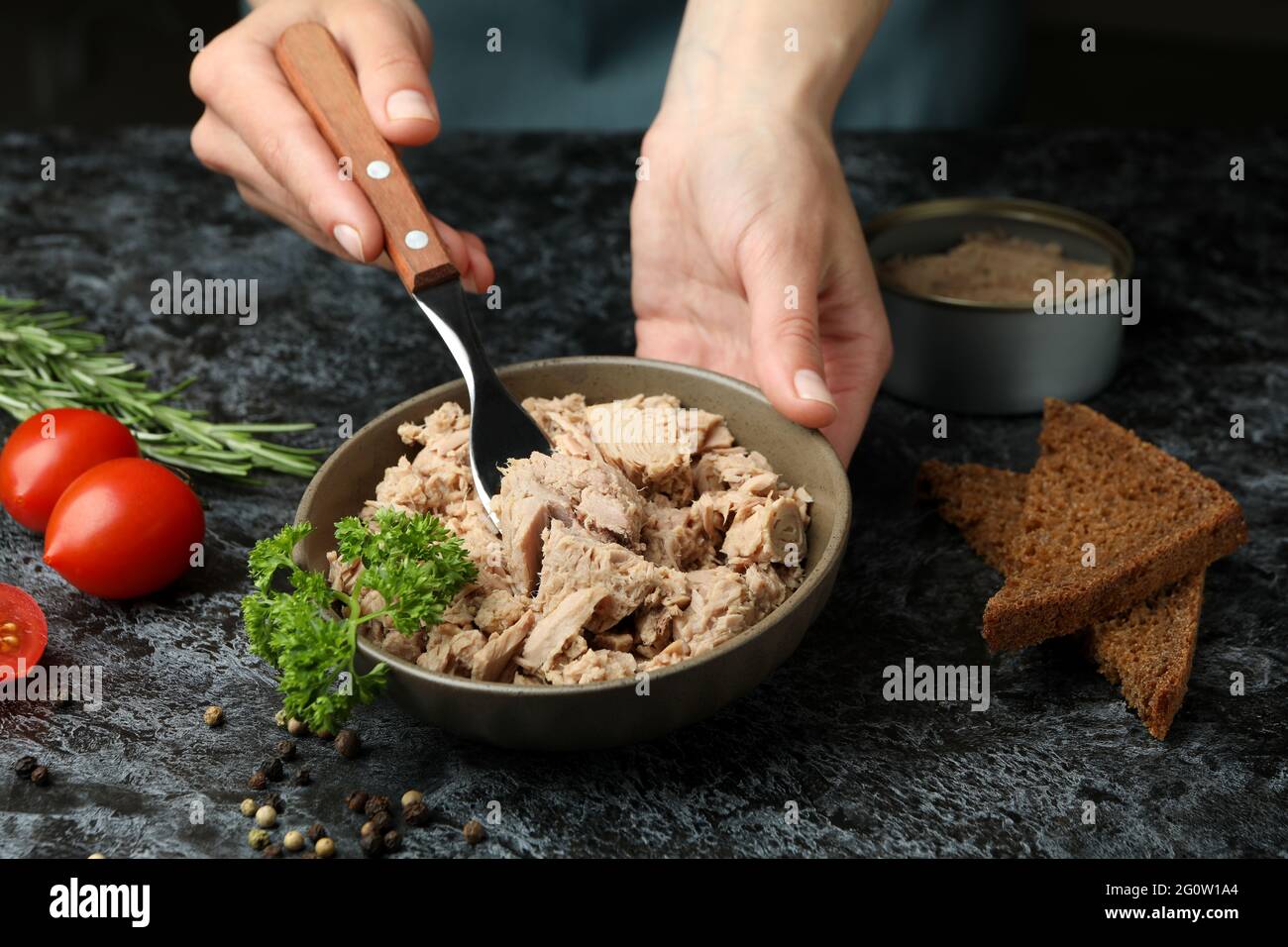 Concept of tasty eating with canned tuna on black smokey background ...