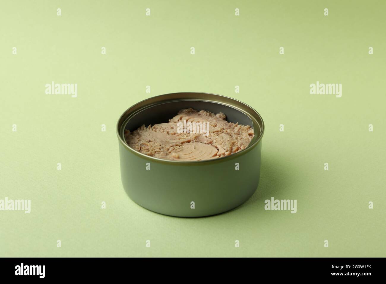 Tin with canned tuna on green background Stock Photo - Alamy