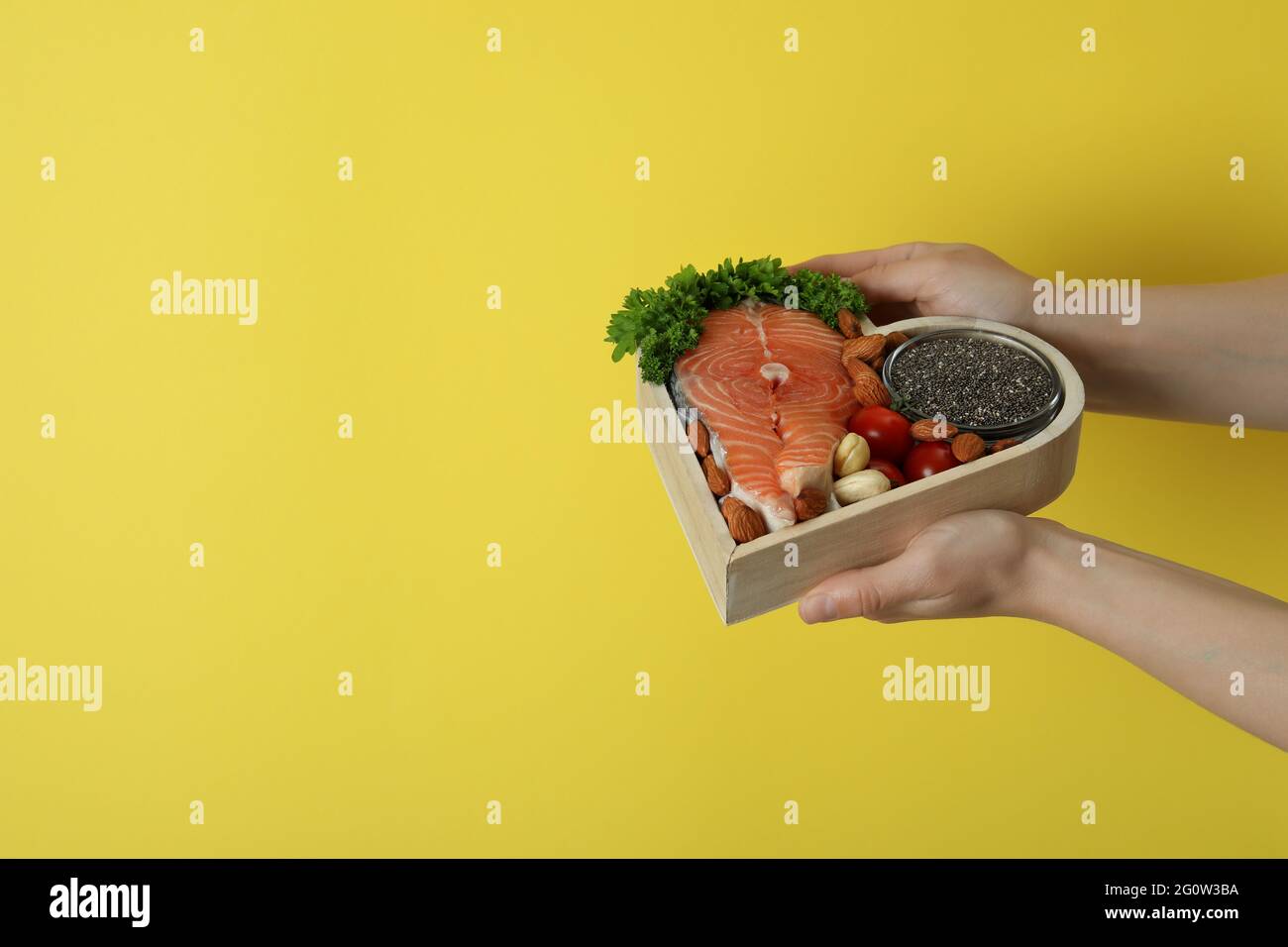 Female hands hold healthy food on yellow background Stock Photo - Alamy