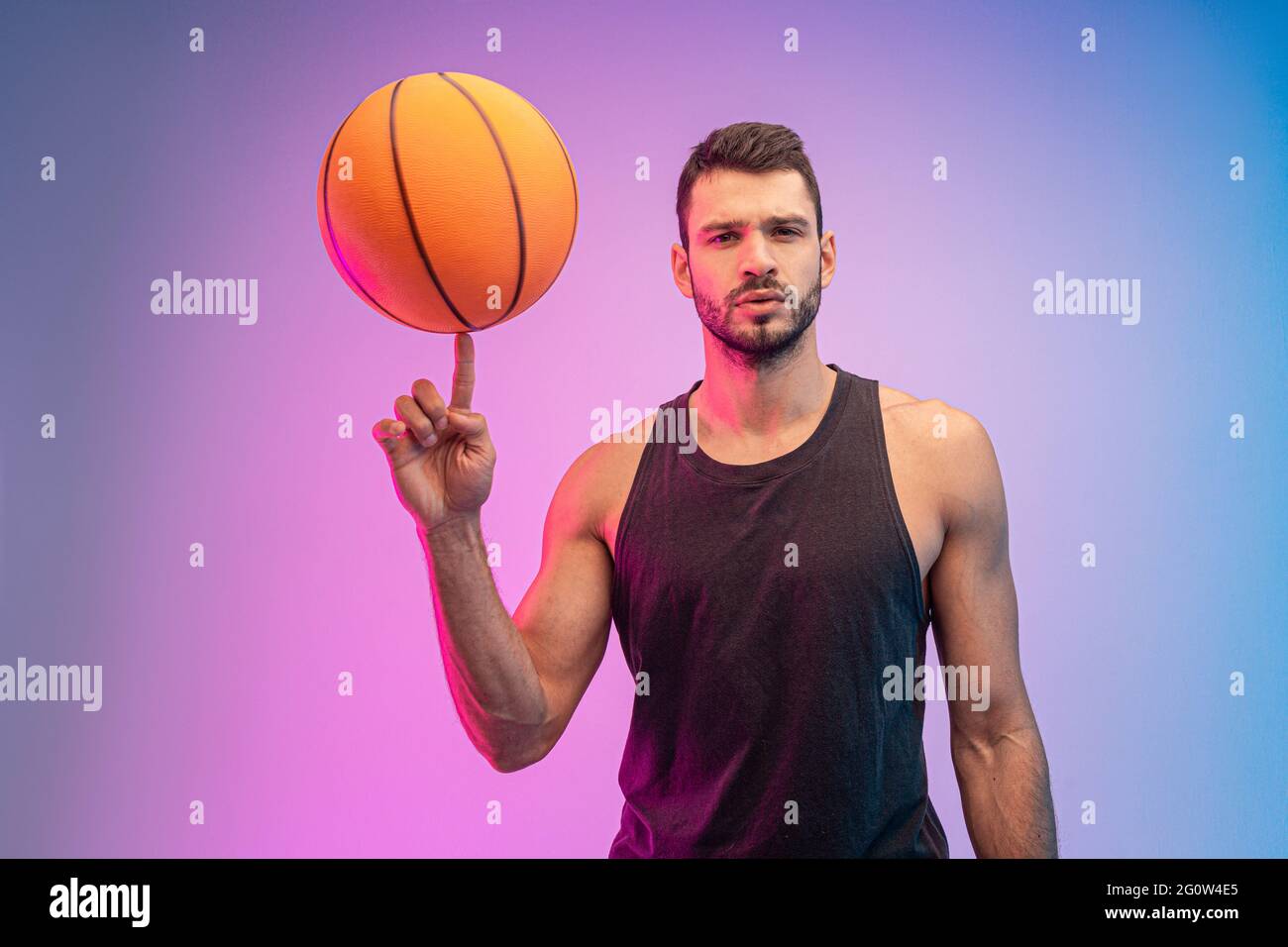 Young sportsman spinning basketball ball on finger Stock Photo - Alamy