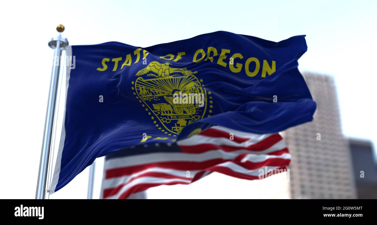 The flags of the Oregon state and United States waving in the wind ...