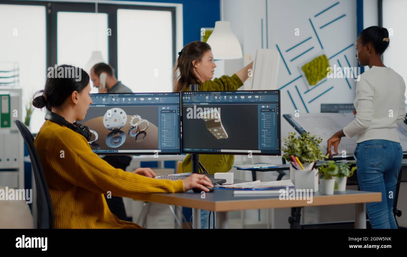 Industrial female engineer looking at personal computer with dual ...