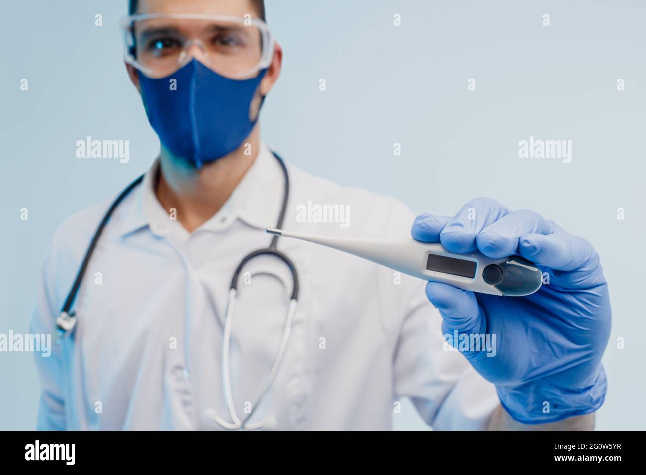 Young doctor examining thermometer measuring hi-res stock photography ...