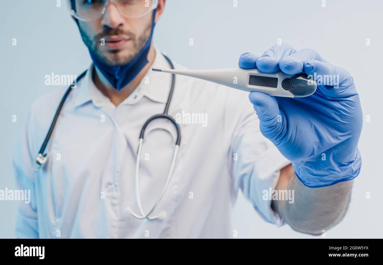 Male doctor showing digital thermometer in arm Stock Photo - Alamy