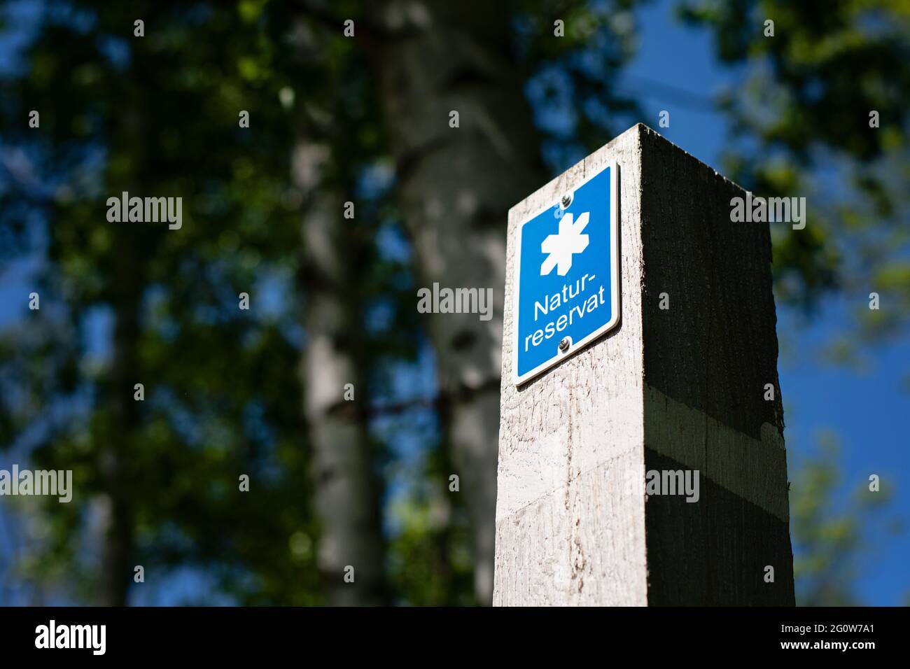 Wooden trail post and sign informing in Swedish that this is a nature ...