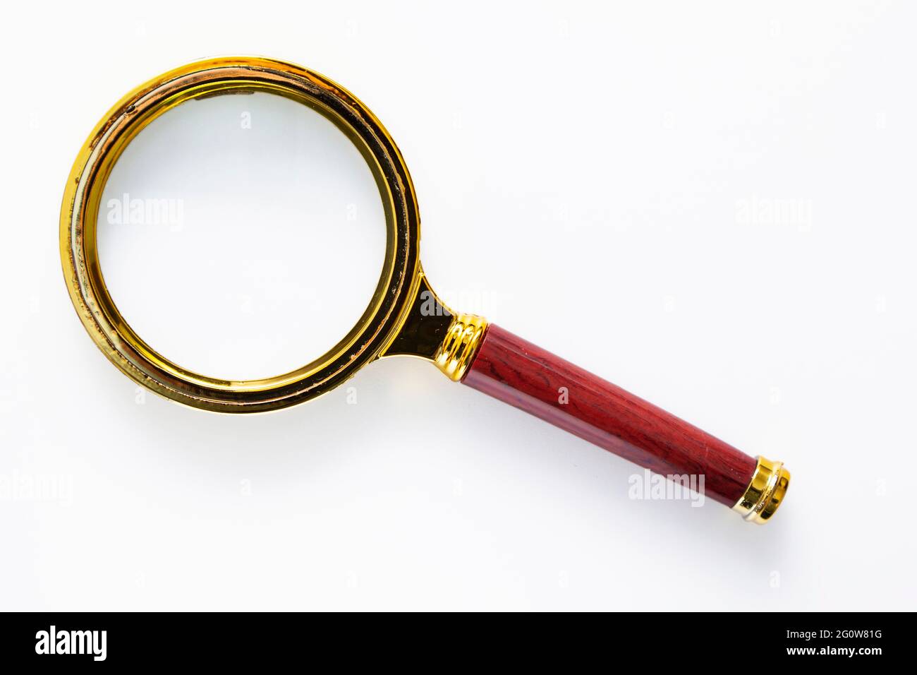 Golden magnifying glass with the plastic handle imitating wood isolated ...