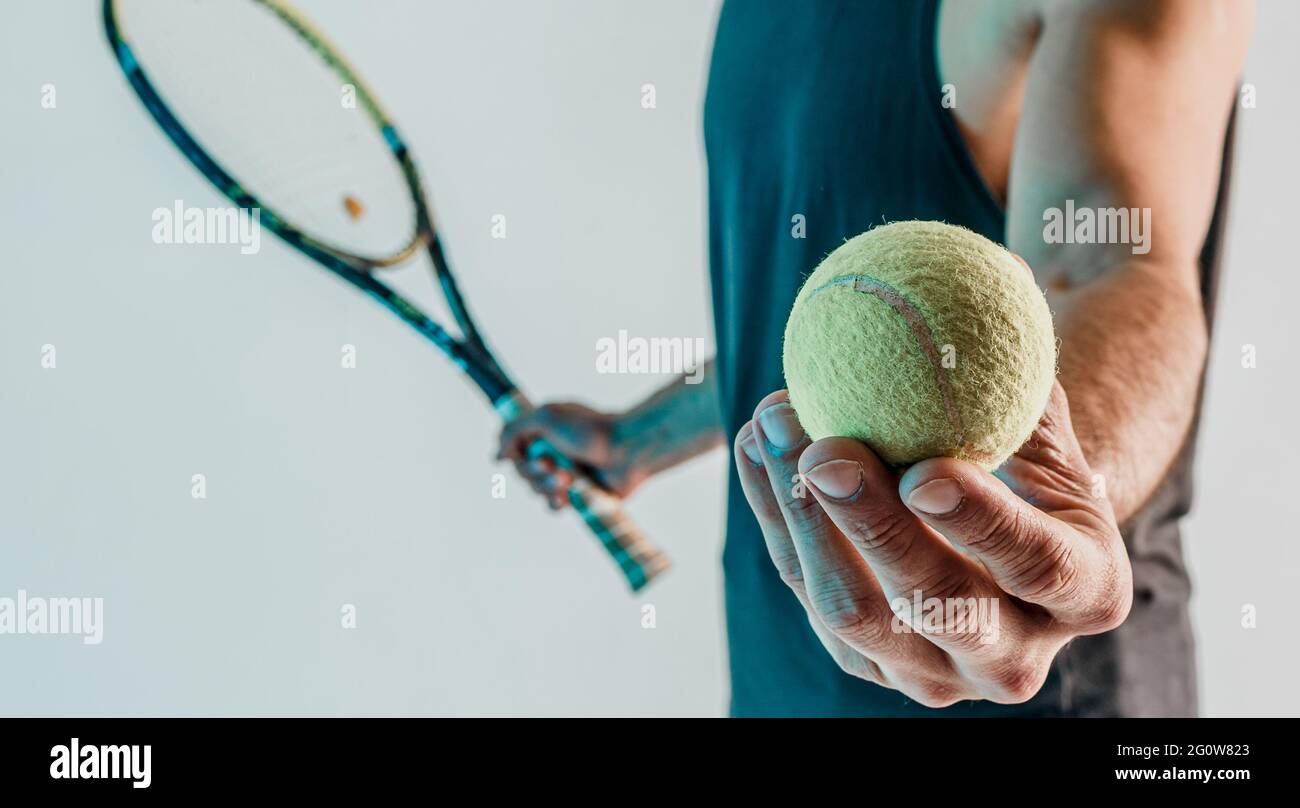 Sportsman hold and showing tennis ball in hand Stock Photo - Alamy