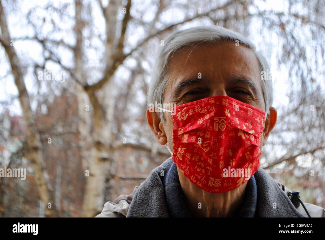 Portrait of handsome senior man wears red color mask with Chinese Luck ...