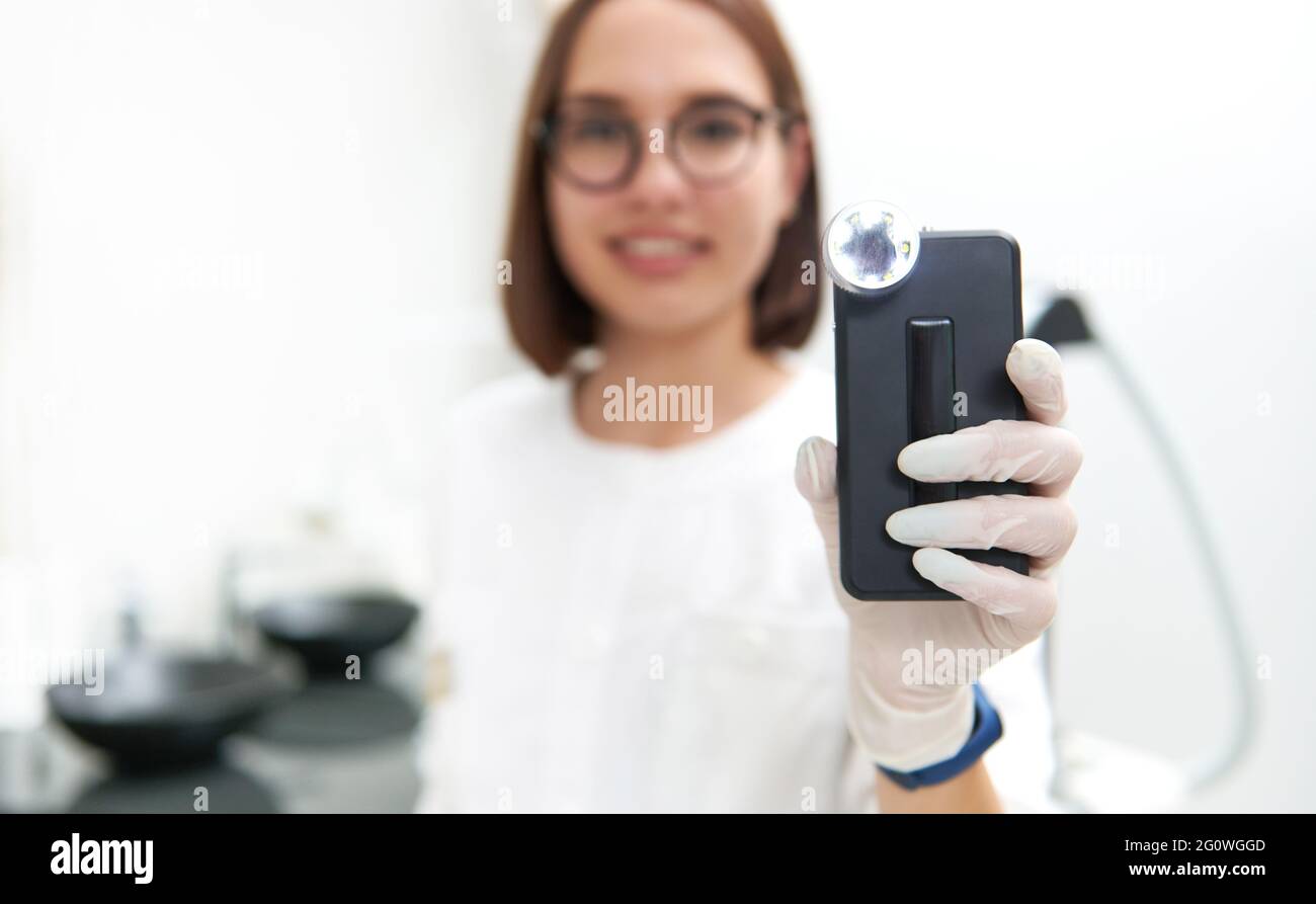 Focus on a dermatoscope to analyze and examine moles and skin growths ...