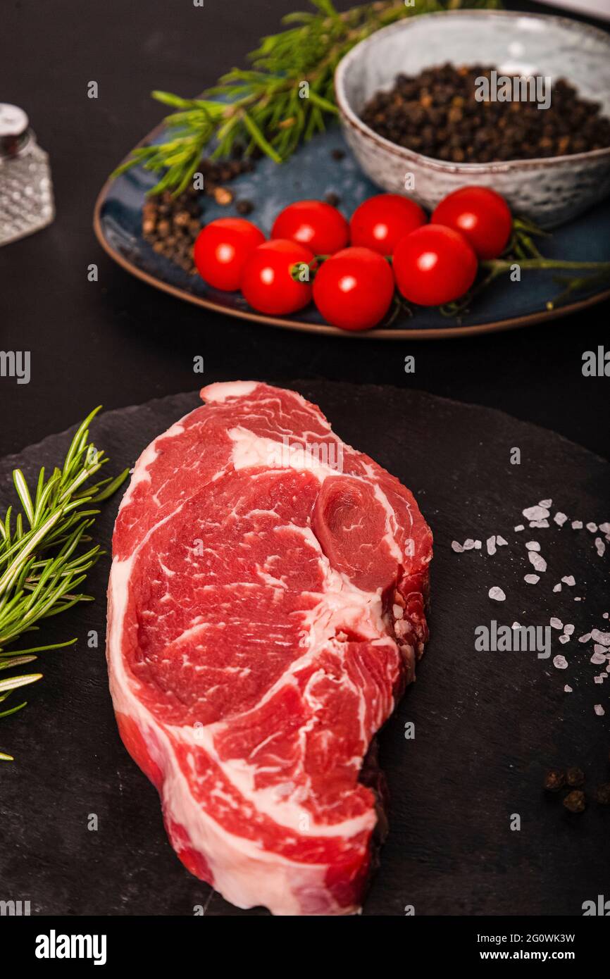 Raw colored beef meat on a slate board ready for grilling. Vertical ...