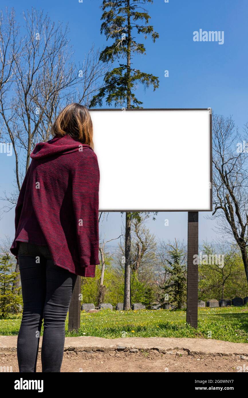 Woman looking at signboard with white blank board for copy space. Add ...