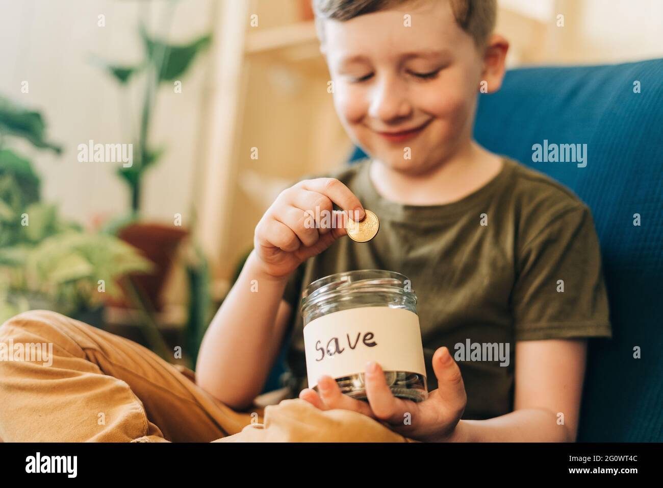 Close up of Little child kid boy hands grabbing and putting stack coins ...