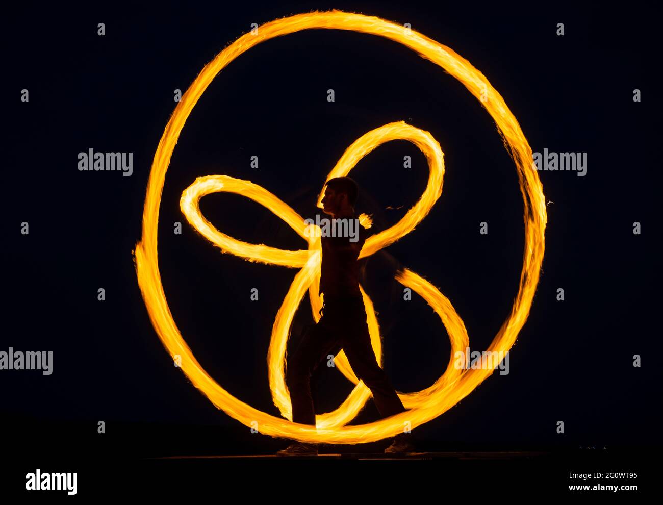 Having tricks for celebration. Man perform fire tricks in darkness ...