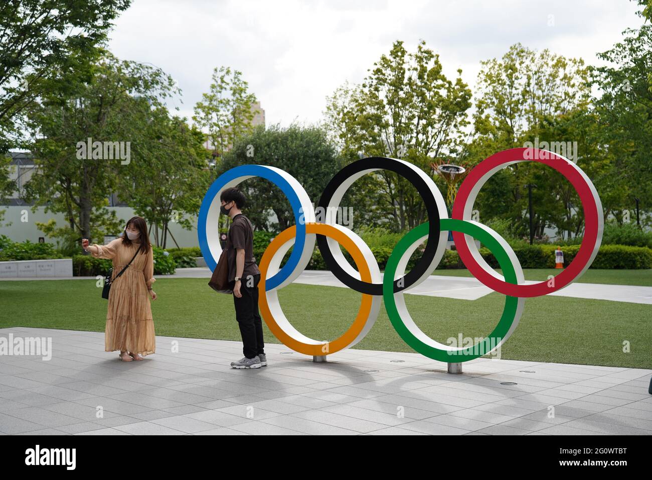 A couple taking selfies next to the Olympic Rings at Japan Olympic ...
