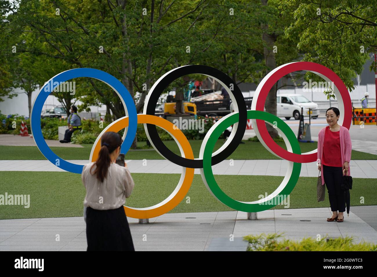 A woman poses for photos next to the Olympic Rings at Japan Olympic ...