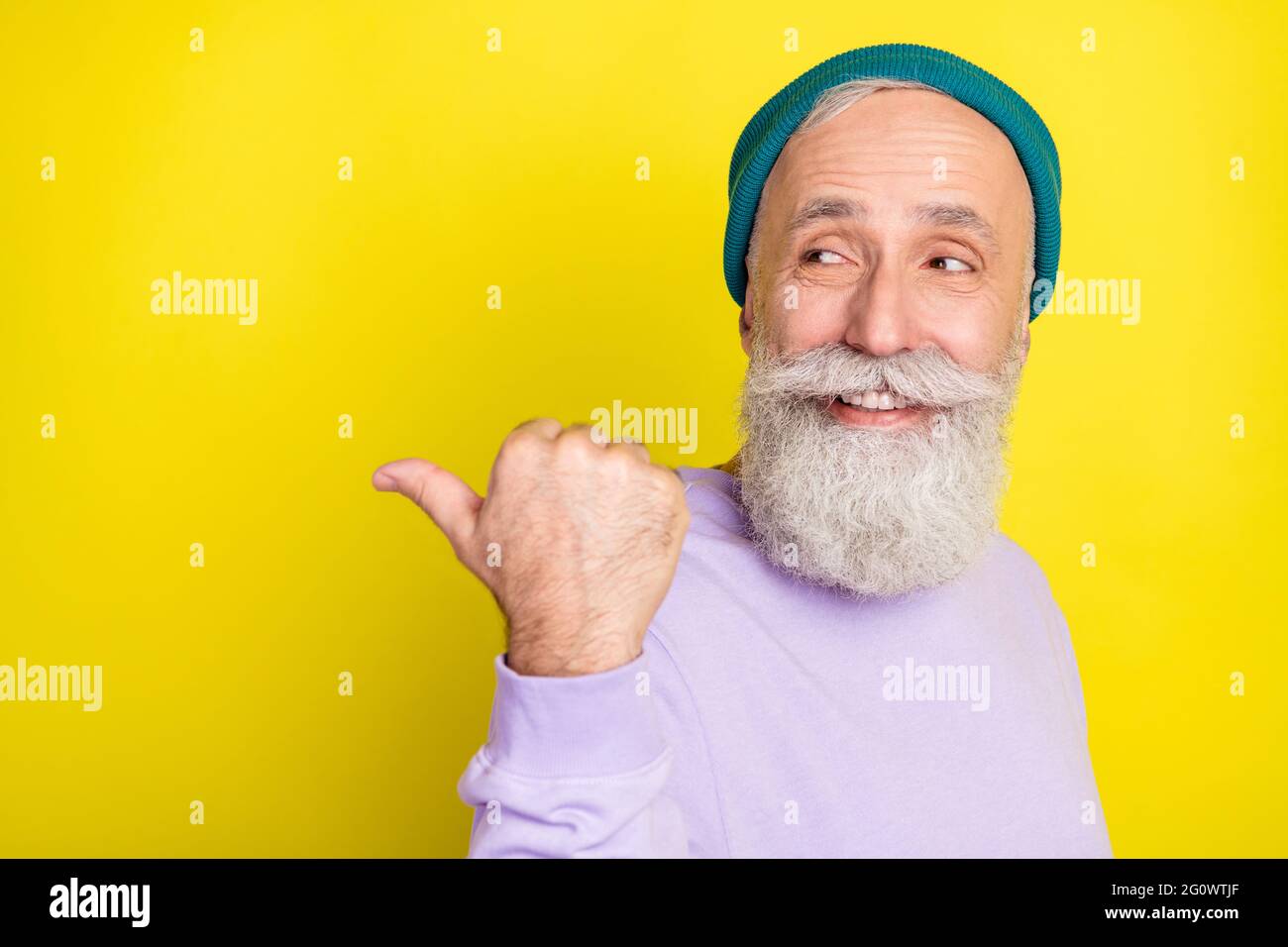 Photo portrait of senior curious dreamy man pointing thumb copyspace advising choosing isolated ...