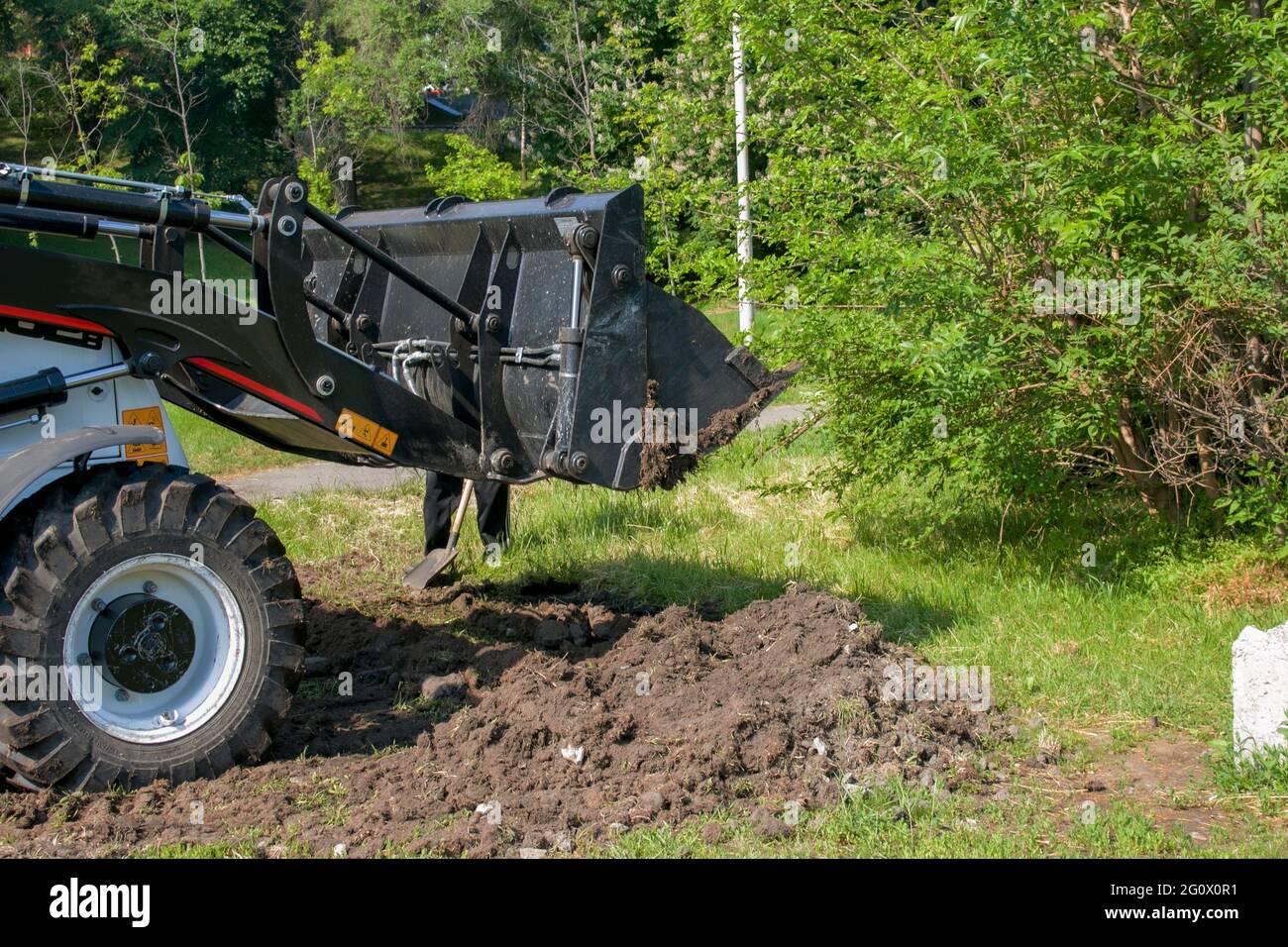 Earthworks in the city park. Unloading and leveling the ground for the ...