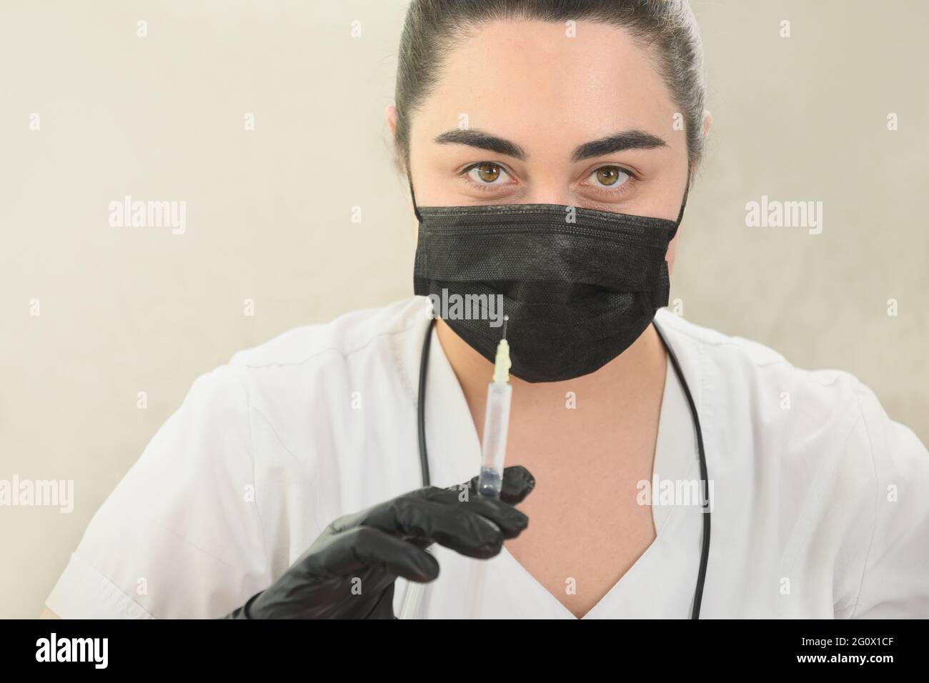 Portrait caucasian woman doctor holds and prepares a syringe for ...