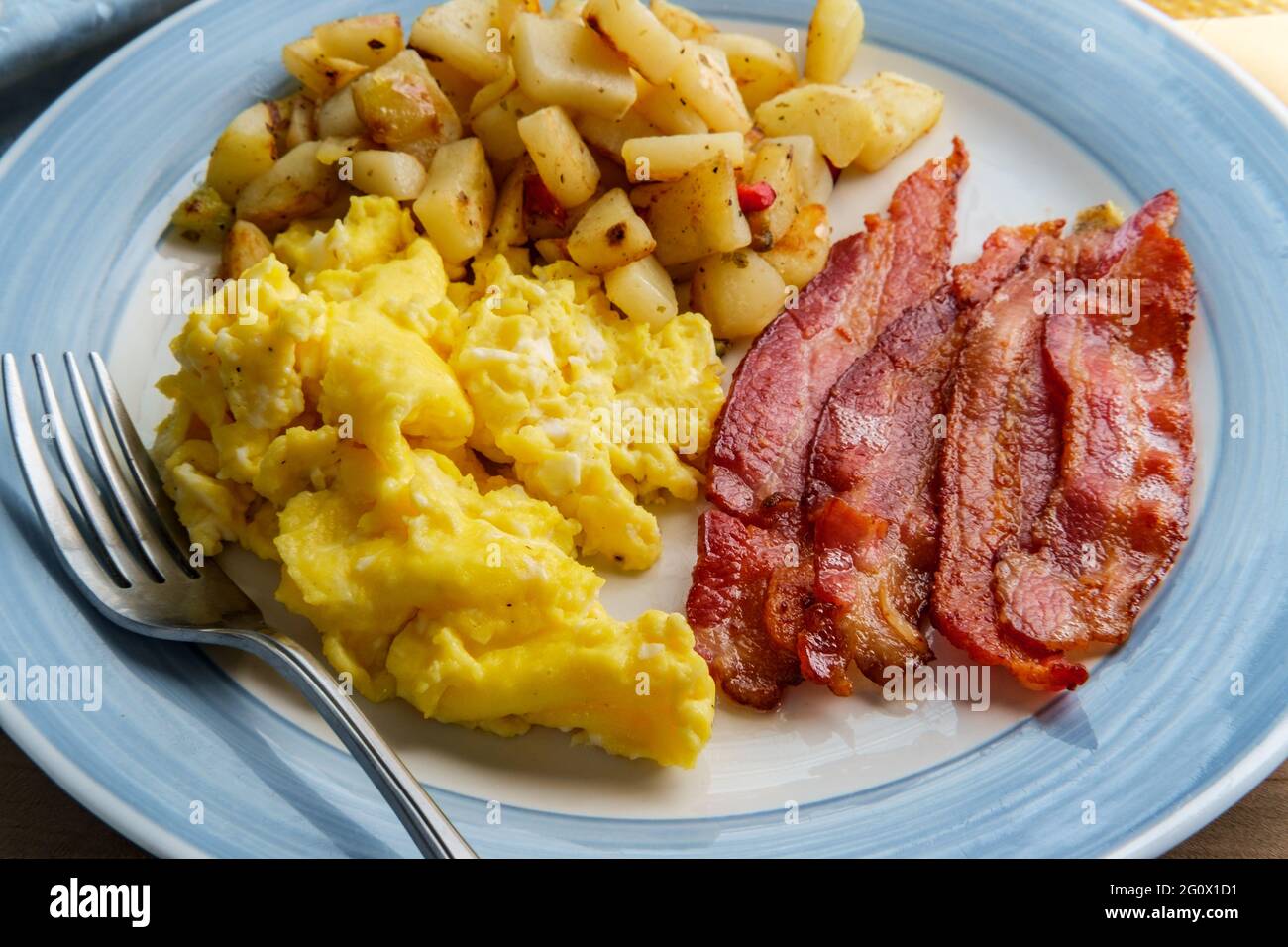 American breakfast food scrambled eggs with home fries and crispy bacon Stock Photo - Alamy