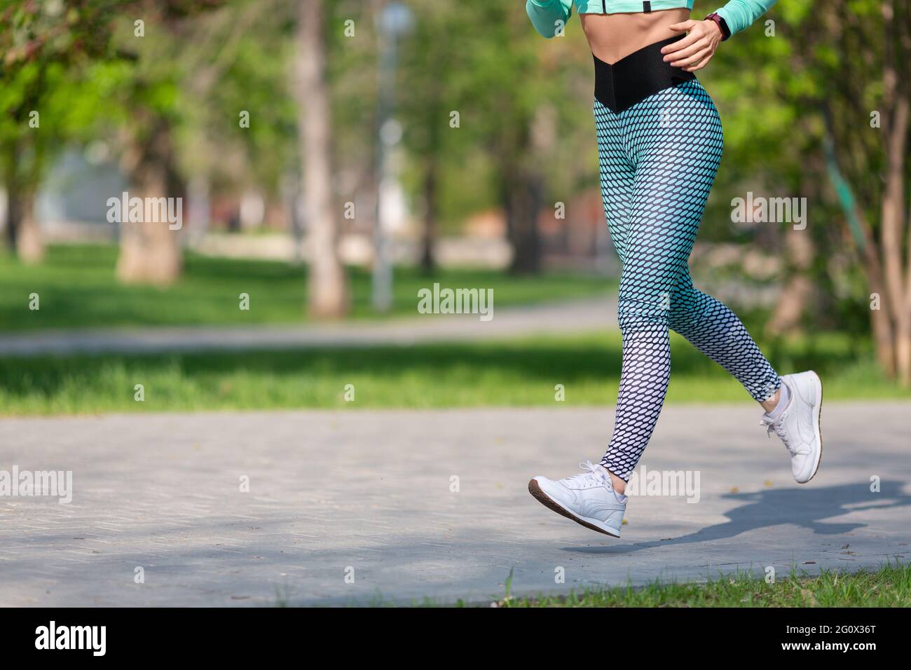 Woman jogging early in the morning in the park. Photo of legs of a ...