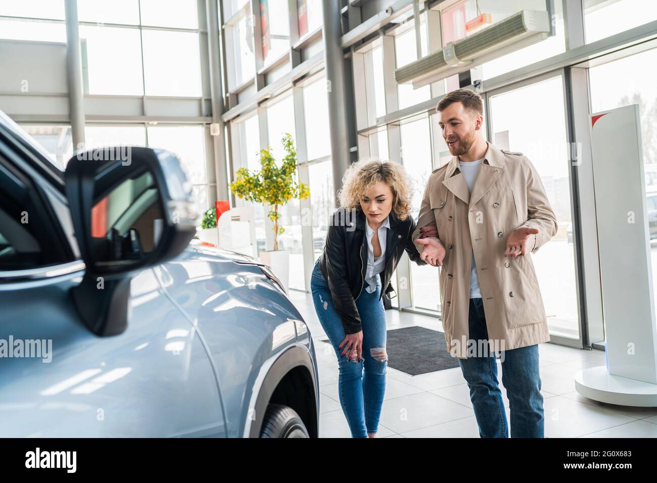Beautiful couple in car dealership chooses car Stock Photo - Alamy