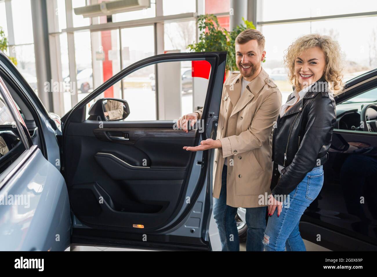 Beautiful couple in car dealership chooses car Stock Photo - Alamy
