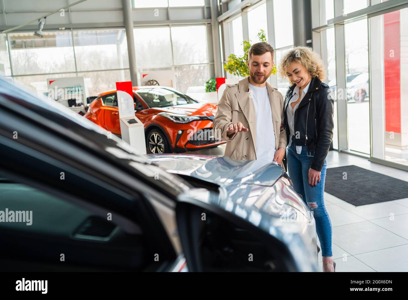 Beautiful couple in car dealership chooses car Stock Photo - Alamy