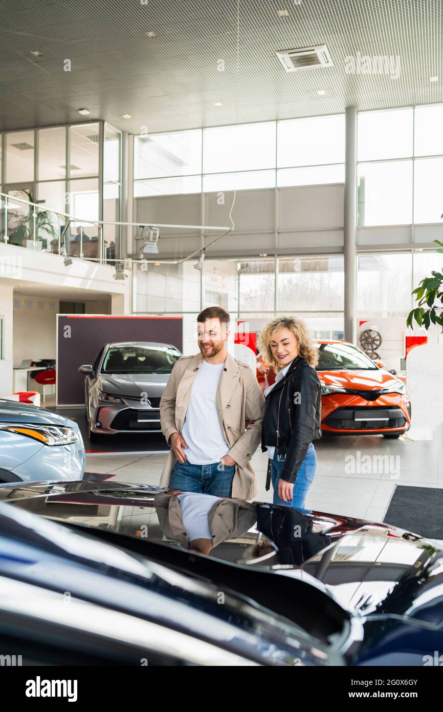 Beautiful couple in car dealership chooses car Stock Photo - Alamy