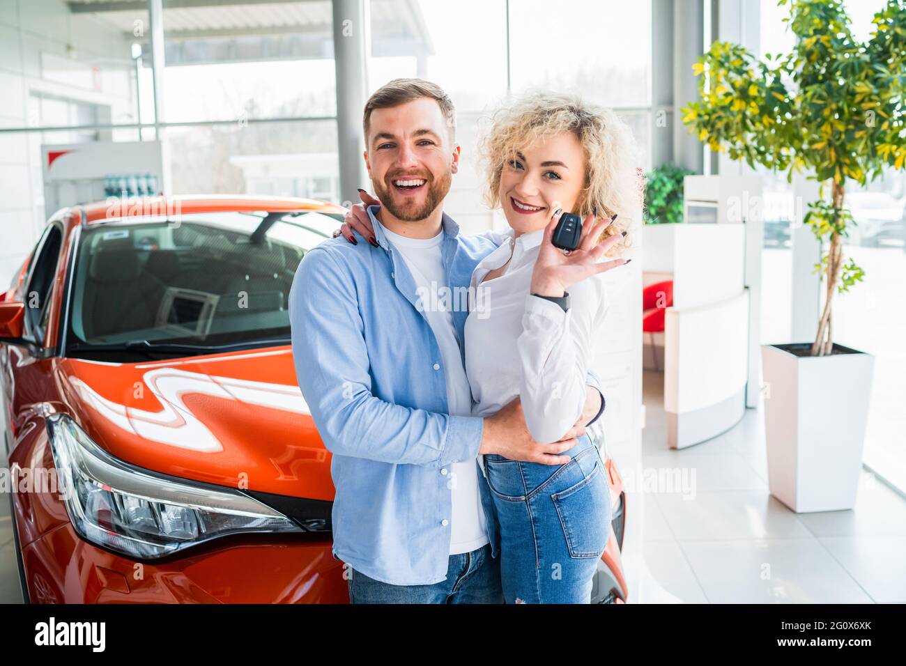 Happy couple in car dealership on the background of their new car Stock ...