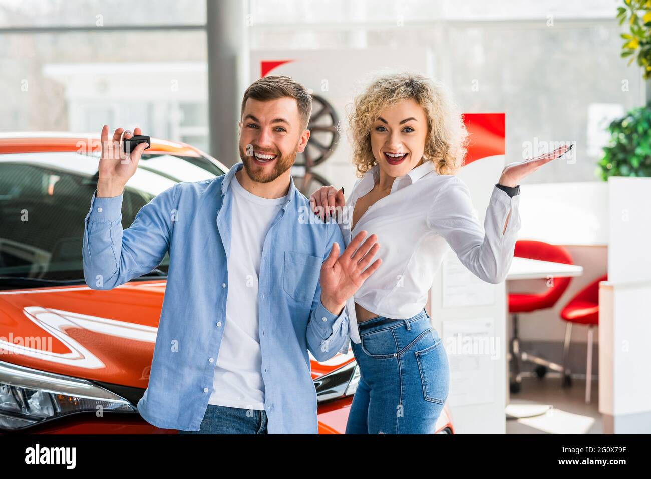 Happy couple in car dealership on the background of their new car Stock ...