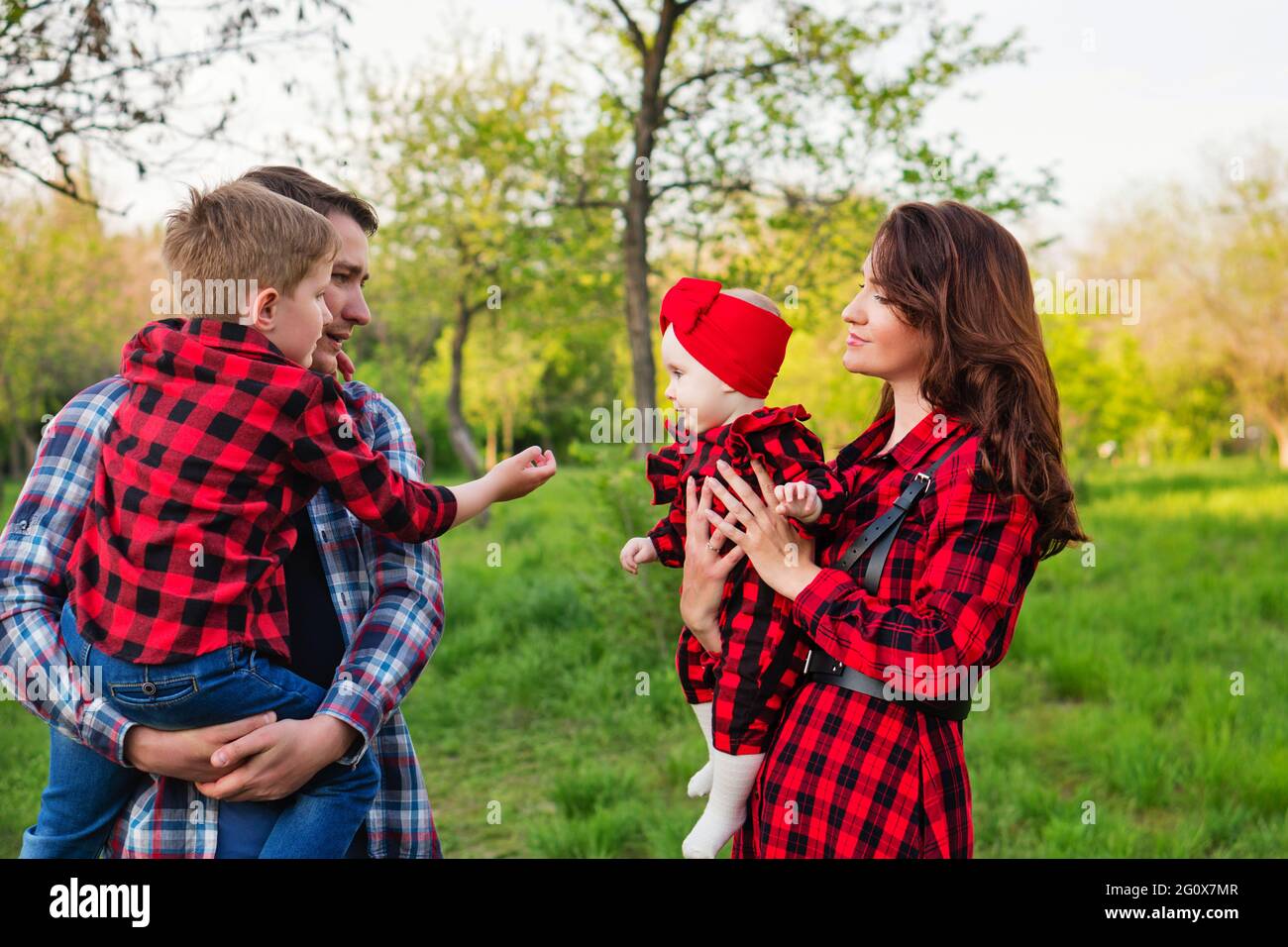 Happy family spend time together outside in green nature. International ...