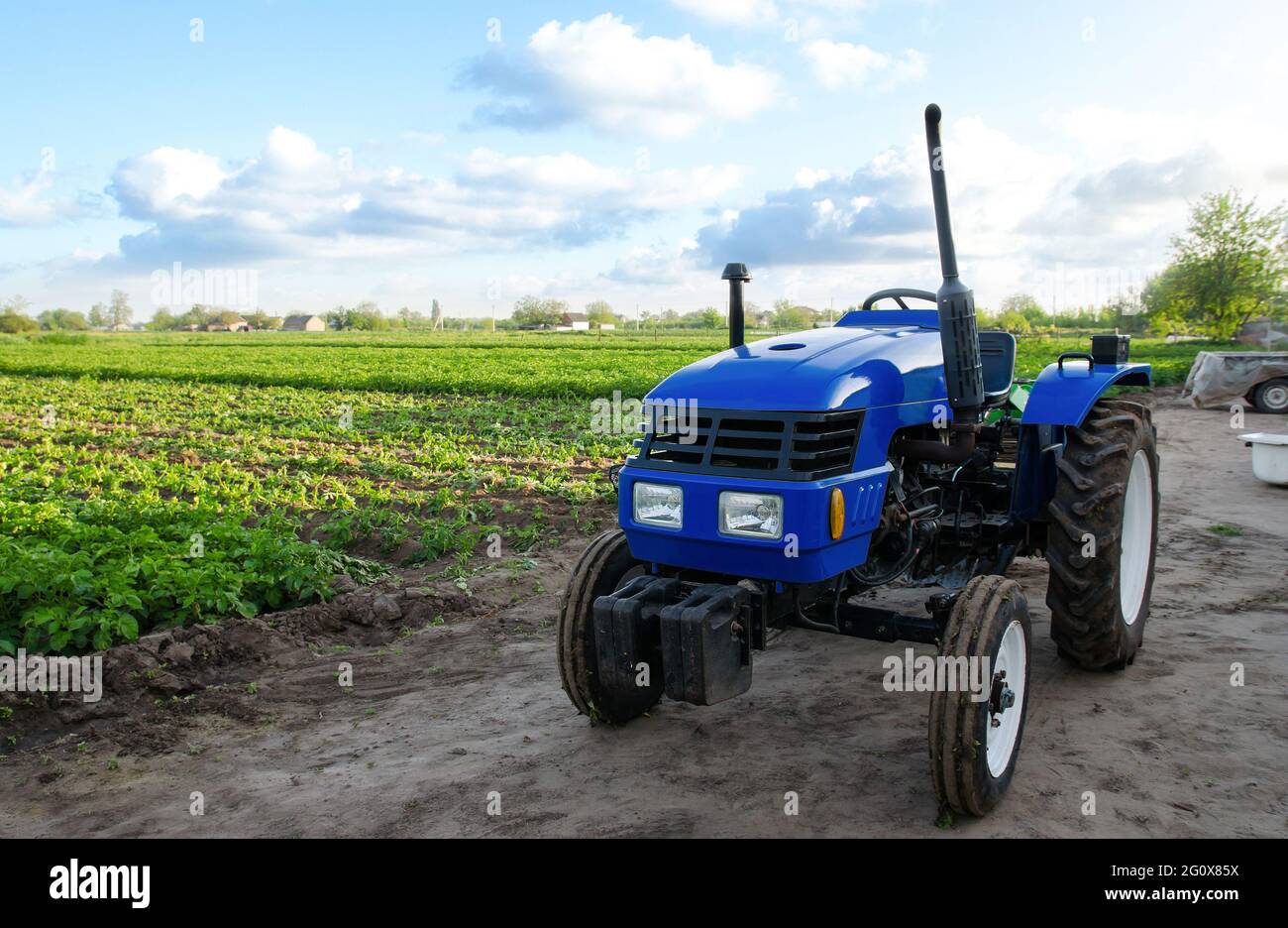 Blue tractor without driver near a farm field. Agricultural machinery ...