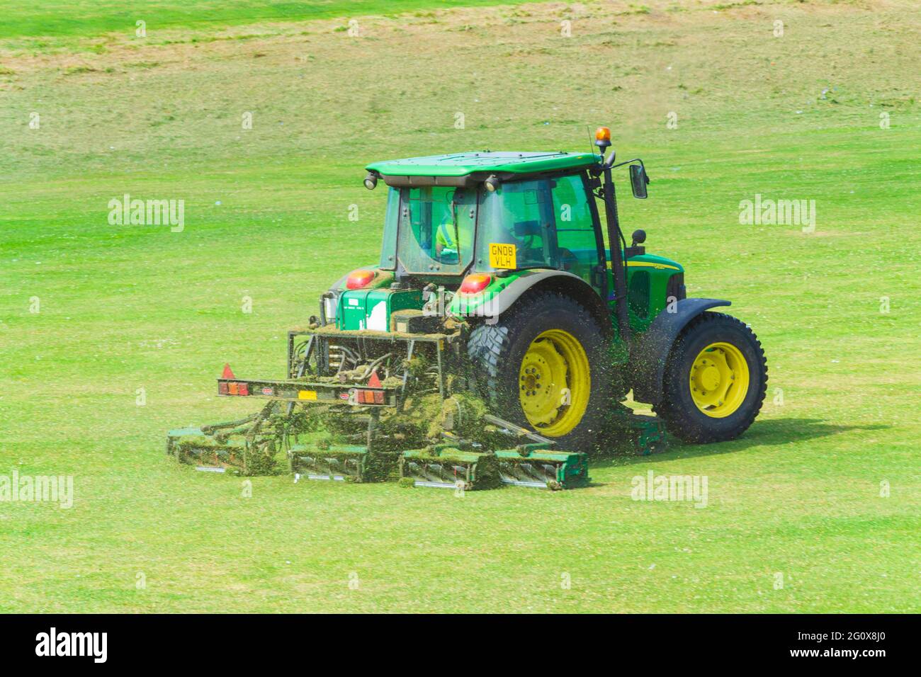 Tractor mows the lawn of a playground at Folkestone town ,Kent,England ...