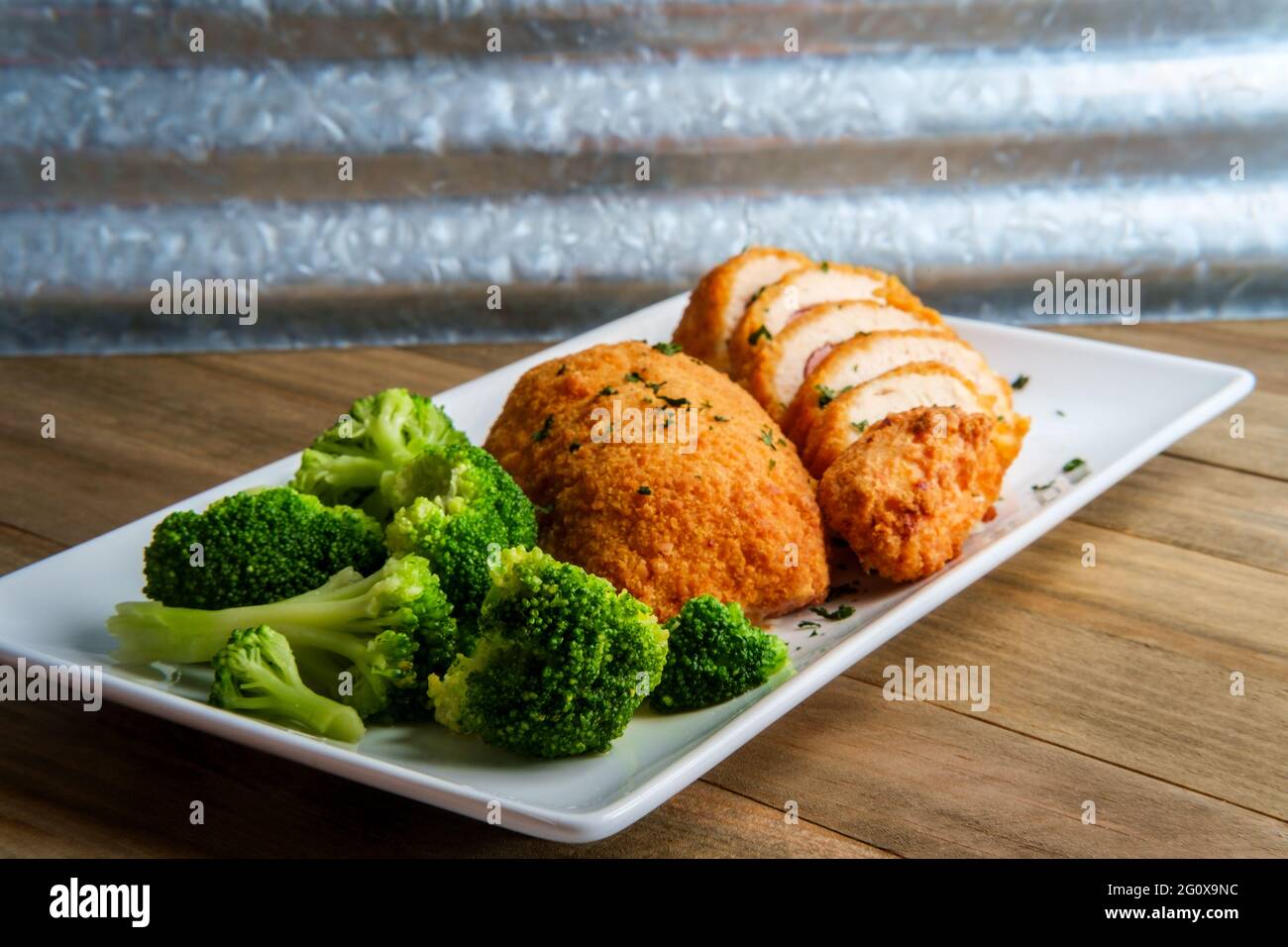 Chicken cordon bleu served with steamed broccoli Stock Photo - Alamy