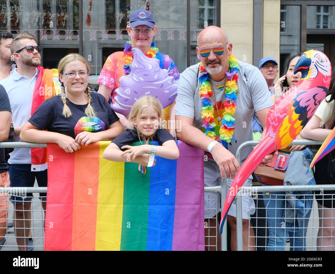 A family attends the Jubilee Pride in London with their rainbow flag ...