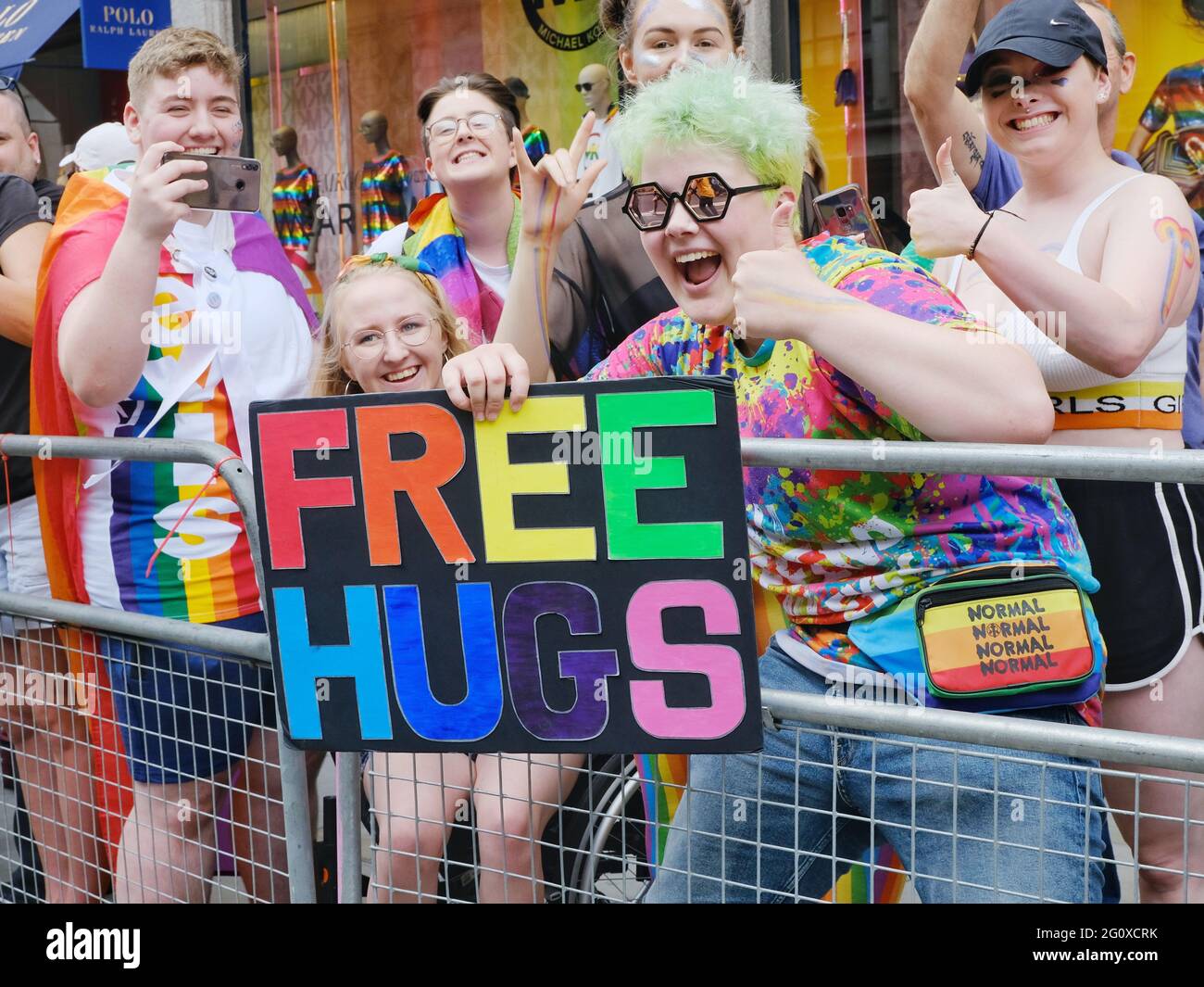 Revellers hold up a 'Free hugs' placard as they watch the Jubilee Pride ...