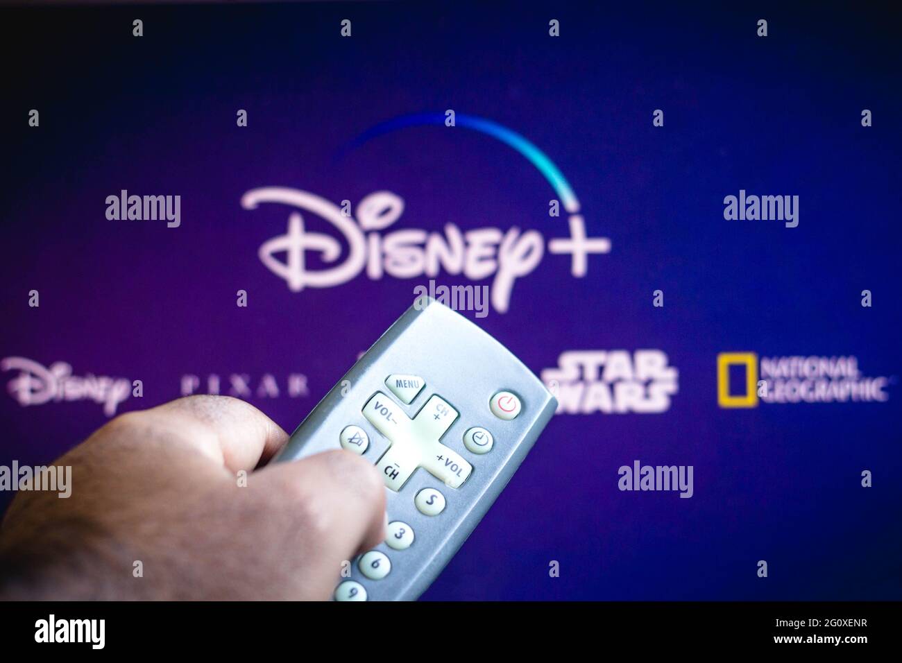 In this photo illustration a person holding a TV remote control and the ...