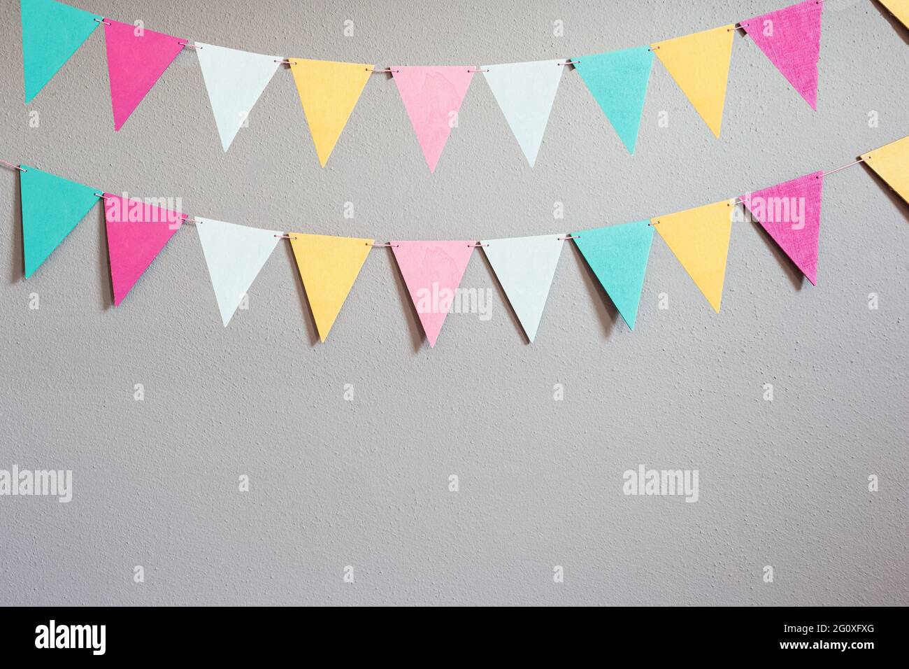 Colorful party flags over cement concrete gray wall texture background ...