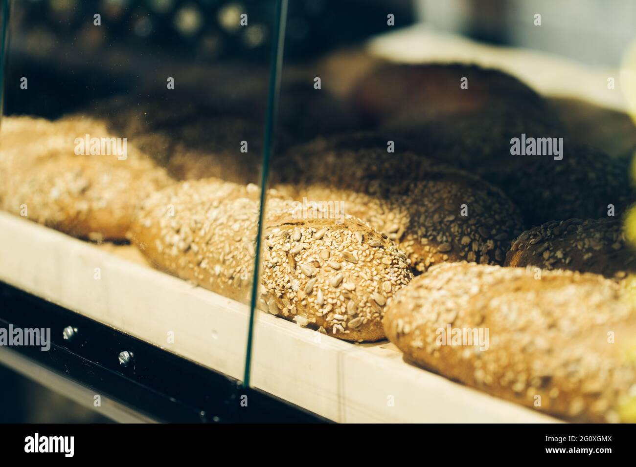 Row of fresh bread loafs with seeds lying on the shelf in bakery Stock ...