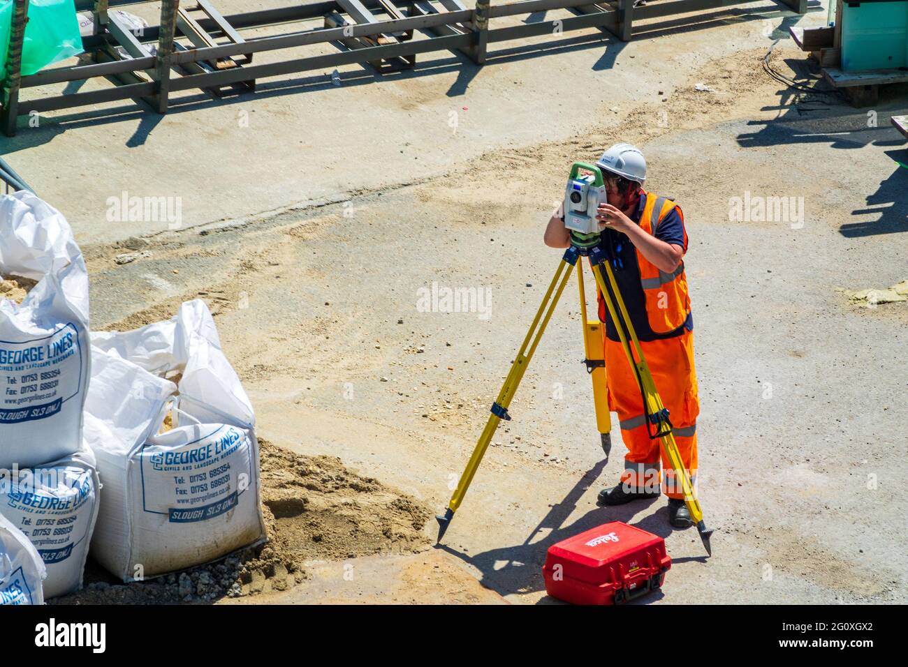 A surveyor on a building construction site using technical equipment ...