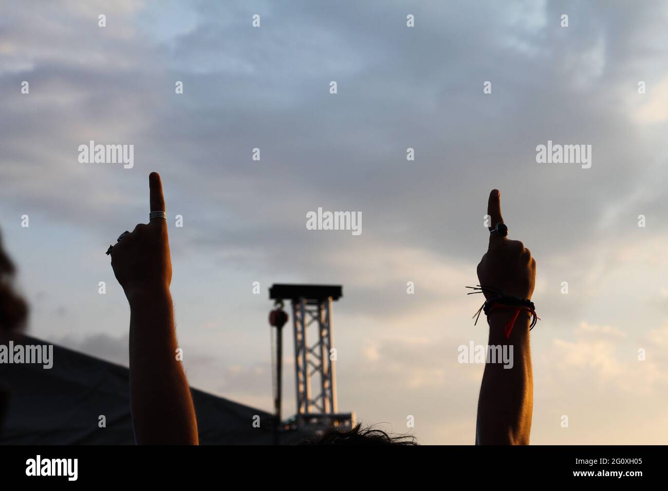 Male with his index fingers raised upwards against the cloudy sky ...