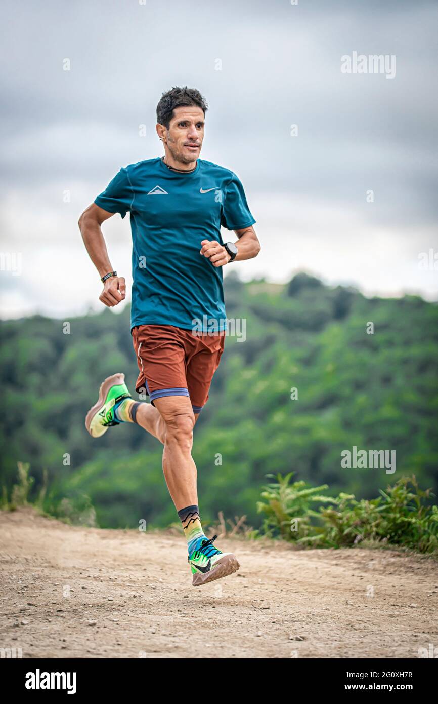 Boy running trail in a mountainous area of and full of trees Stock ...