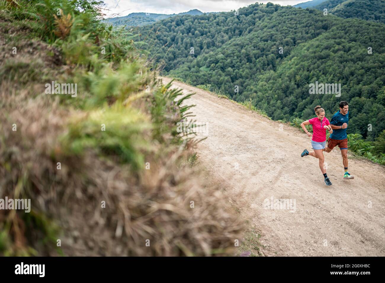 Group of runners running on a trail along beautiful mountain roads ...