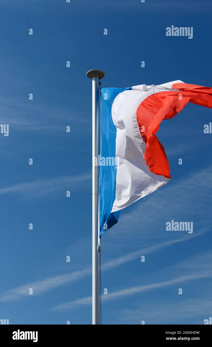 French Flag Tricolor waving from a flag pole with blue sky background ...