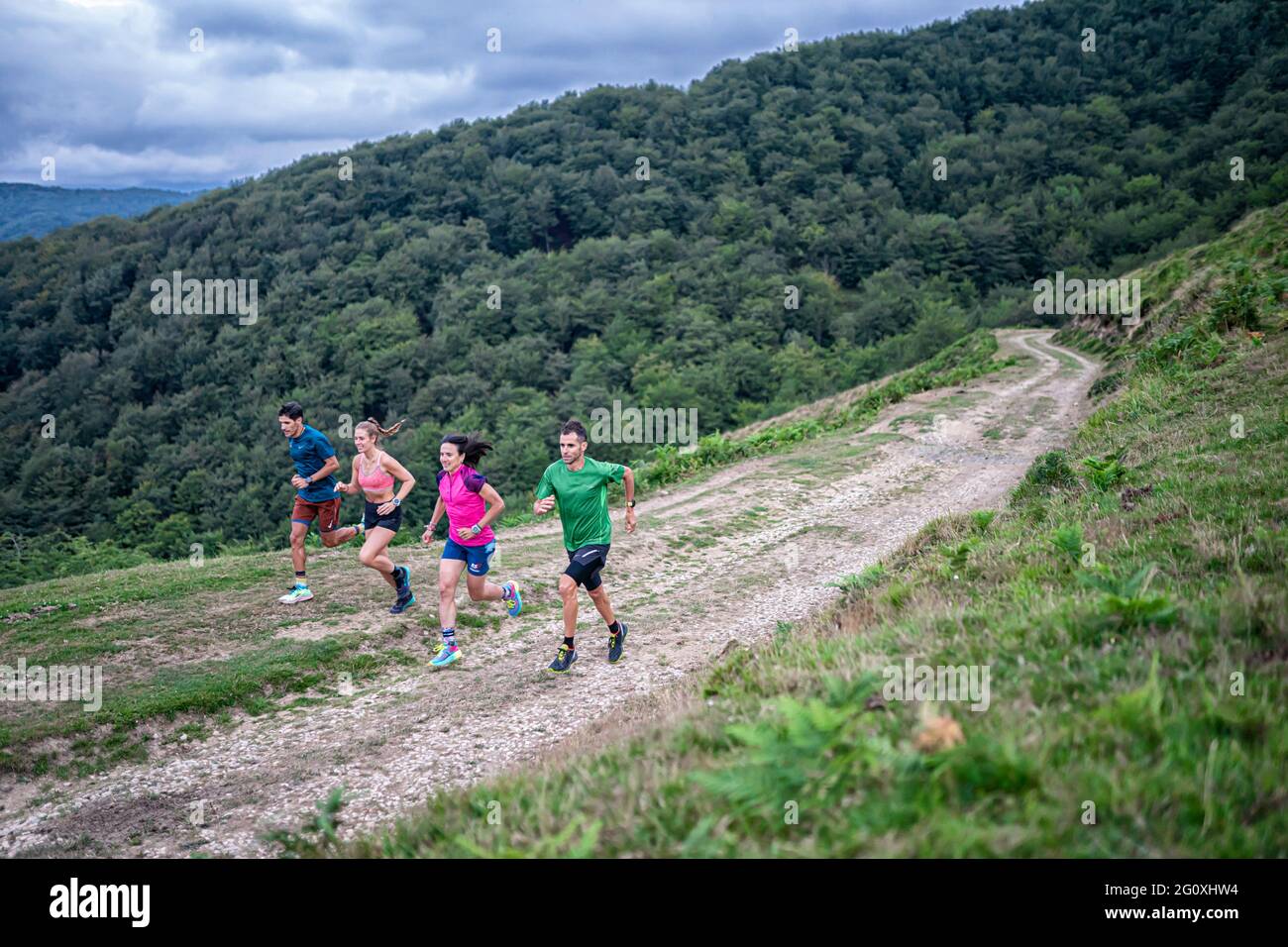 Group of runners running on a trail along beautiful mountain roads ...